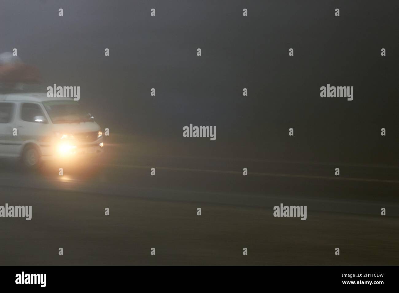 Front part of a minivan in a foggy street with headlights on Stock ...