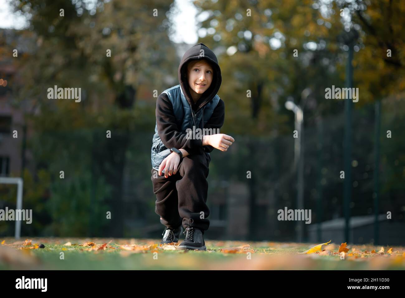boy athlete doing warm-up at the stadium in autumn Stock Photo - Alamy