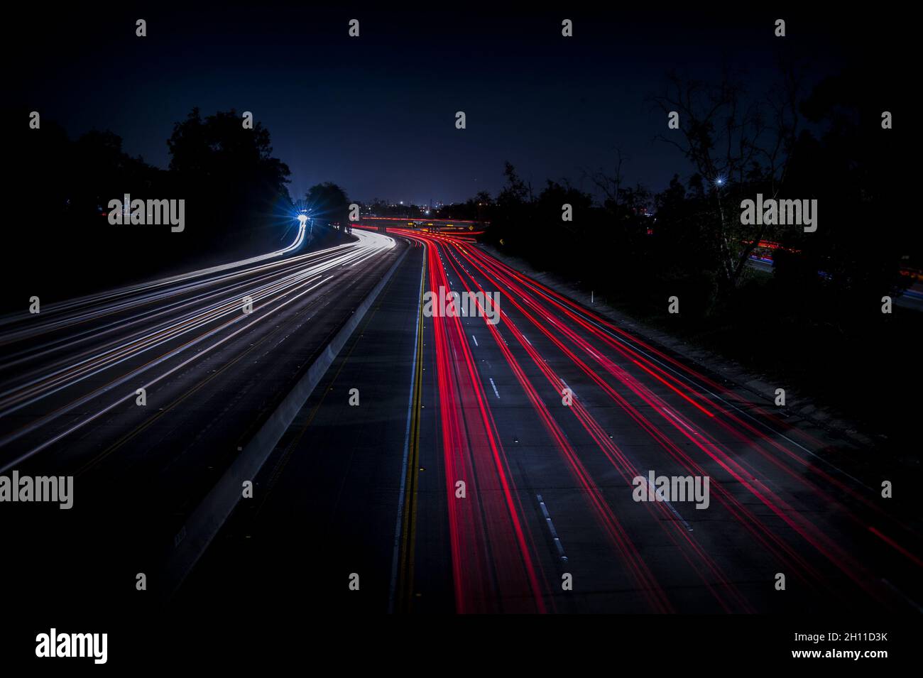 Wide highway with abstract bright traffic light trails at night ...