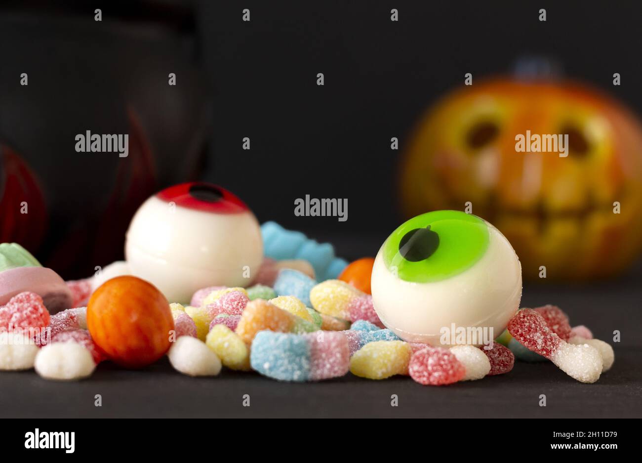 Scary orange pumpkin with colorful candies, to celebrate Halloween ...