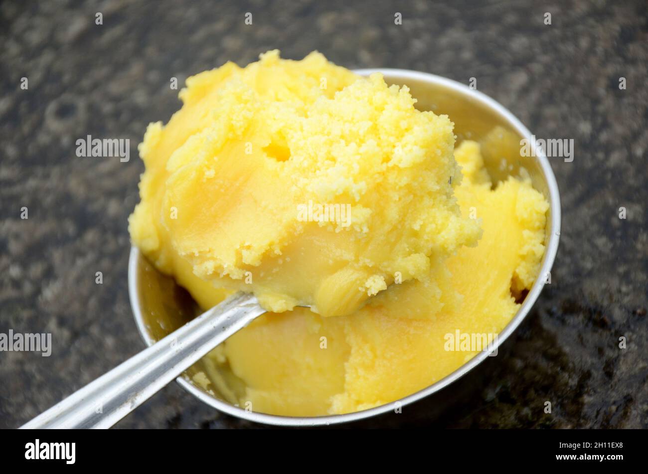 Close-up shot of a small steel bowl of yellow clarified butter Stock ...