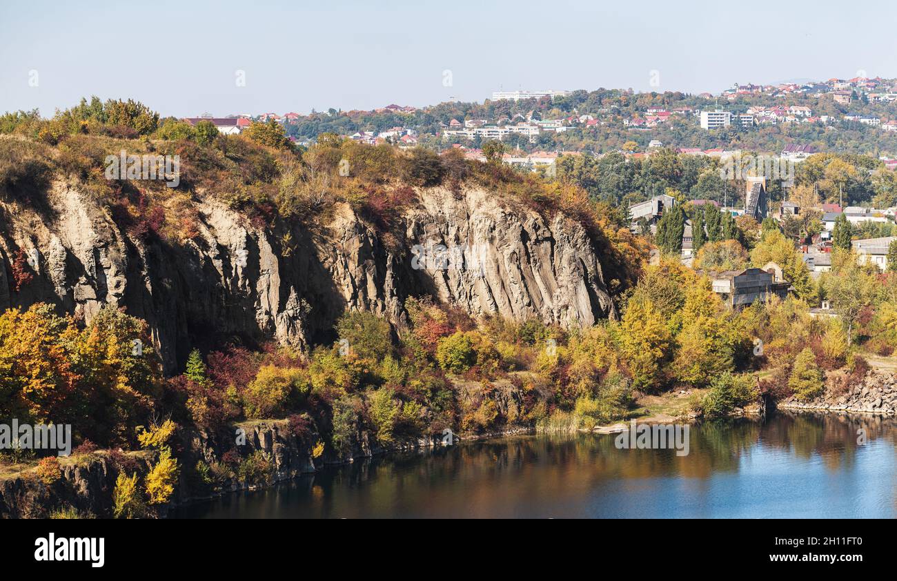 Golden autumn with colourful trees in old flooded quarry. Rocks, lake ...