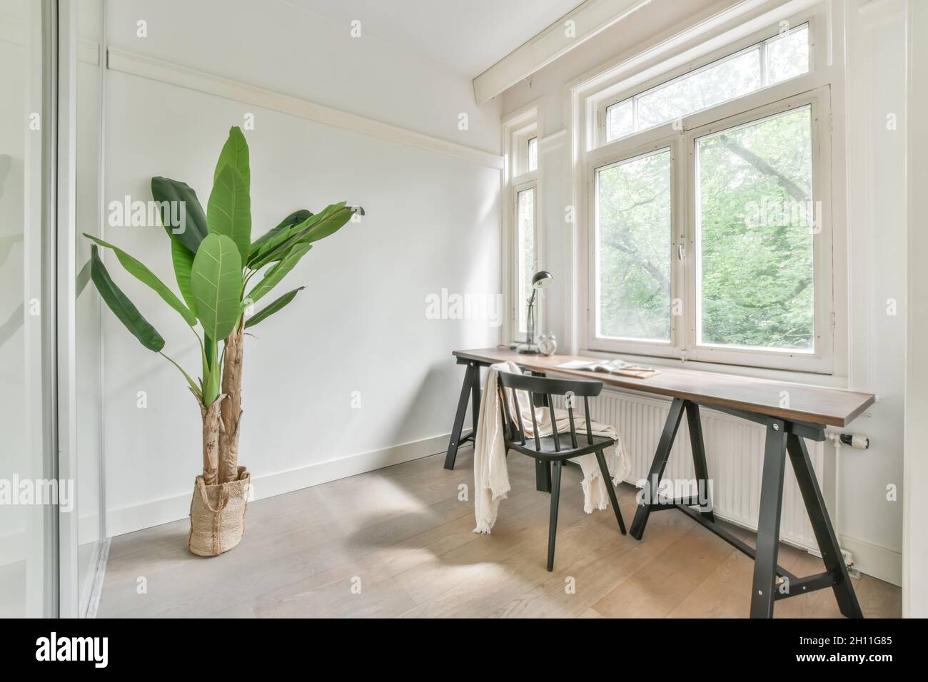 Minimalist style working room with table, chair, and houseplant Stock ...