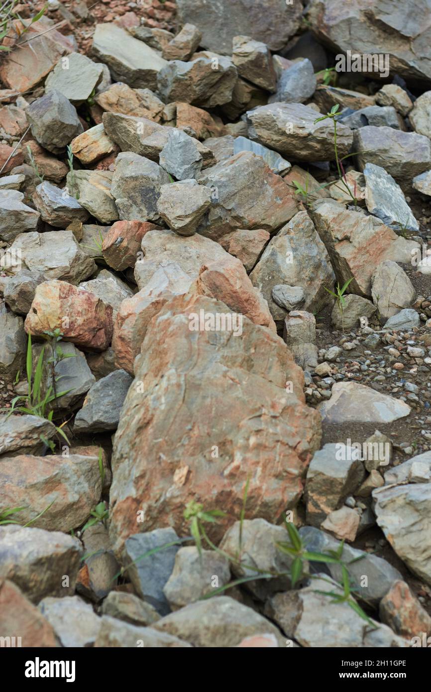 Vertical shot of a big piece of rock against a background with smaller ...