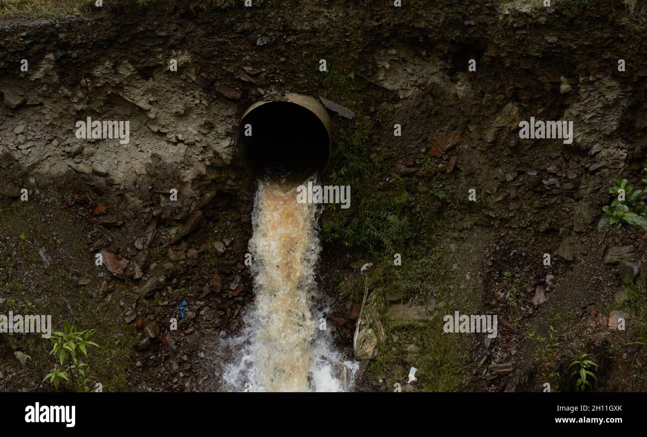 Dirty sewage water flows from the sewer pipe in the wall Stock Photo ...