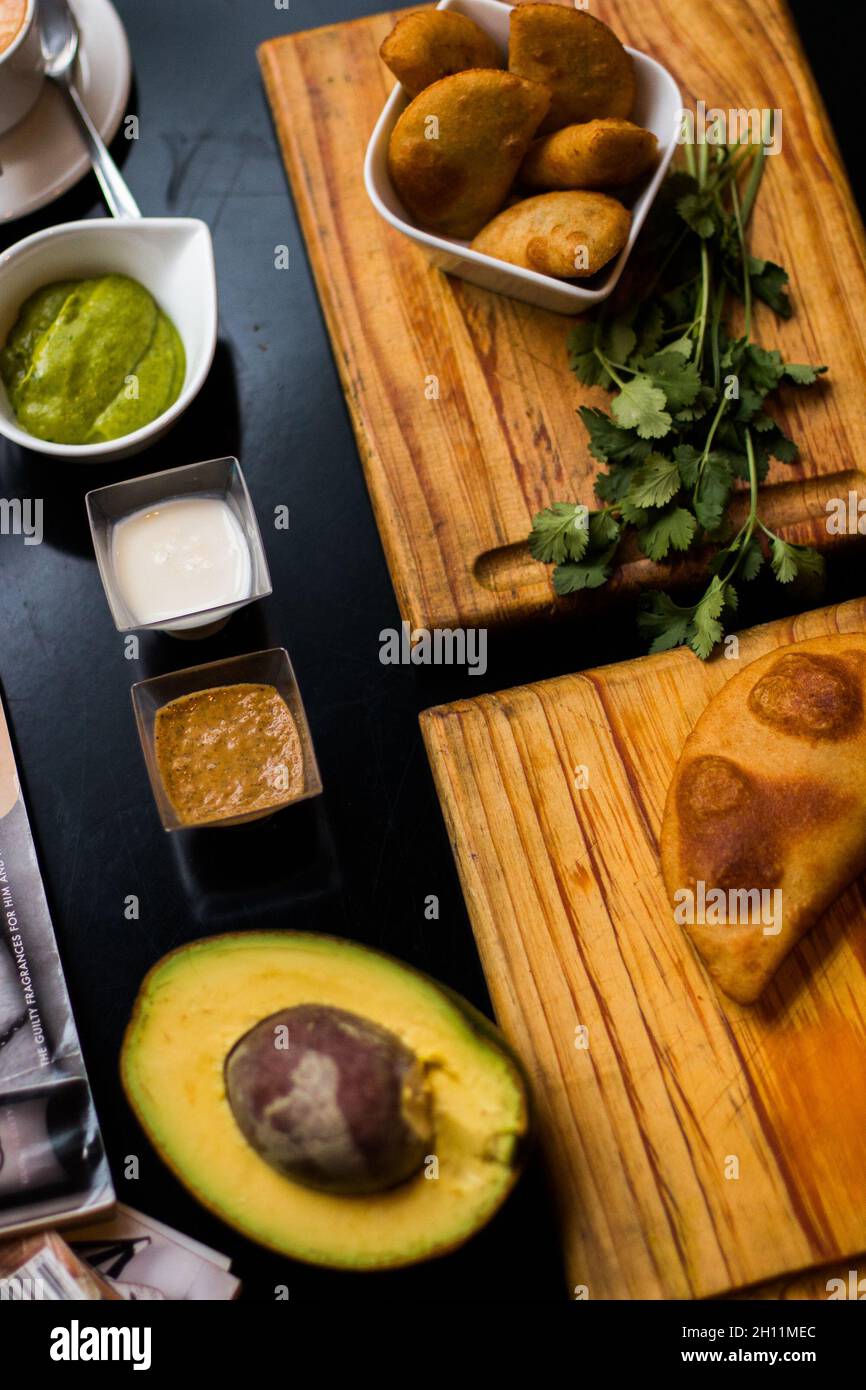 Overhead shot of a bowl of empanada with avocado and dip on a dining ...
