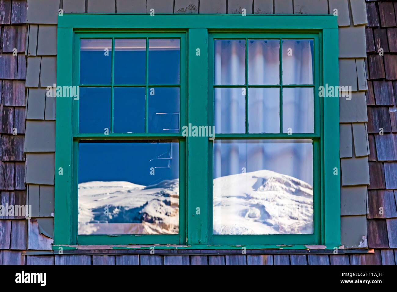 Window of Guide Services Building reflecting Mount Rainier, in Paradise ...