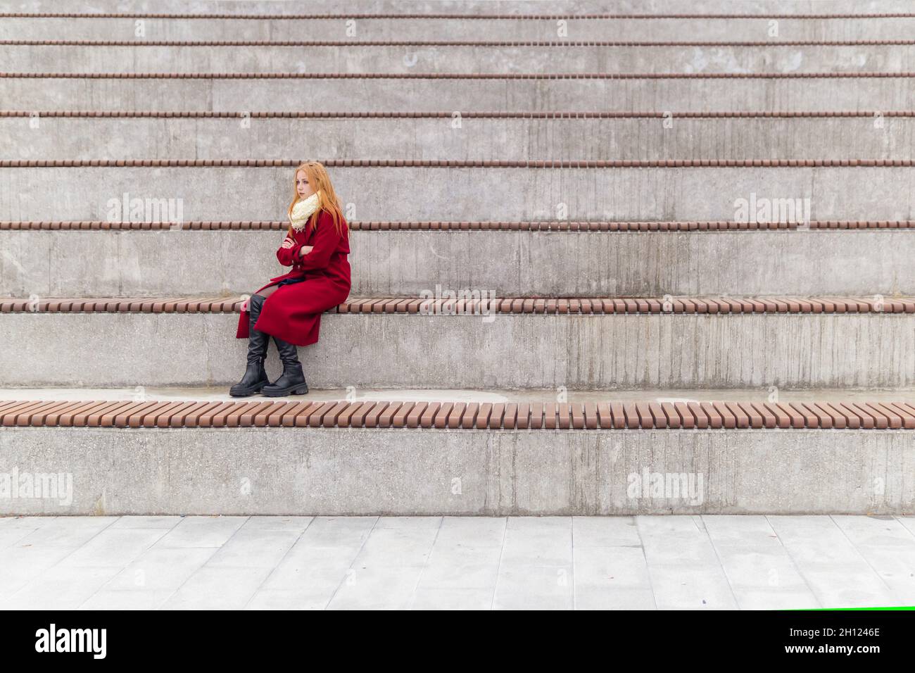 sad young woman sits alone in empty stands Stock Photo - Alamy