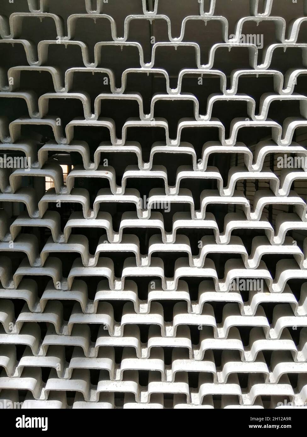 Vertical shot of a pattern of a metallic surface behind chairs Stock ...