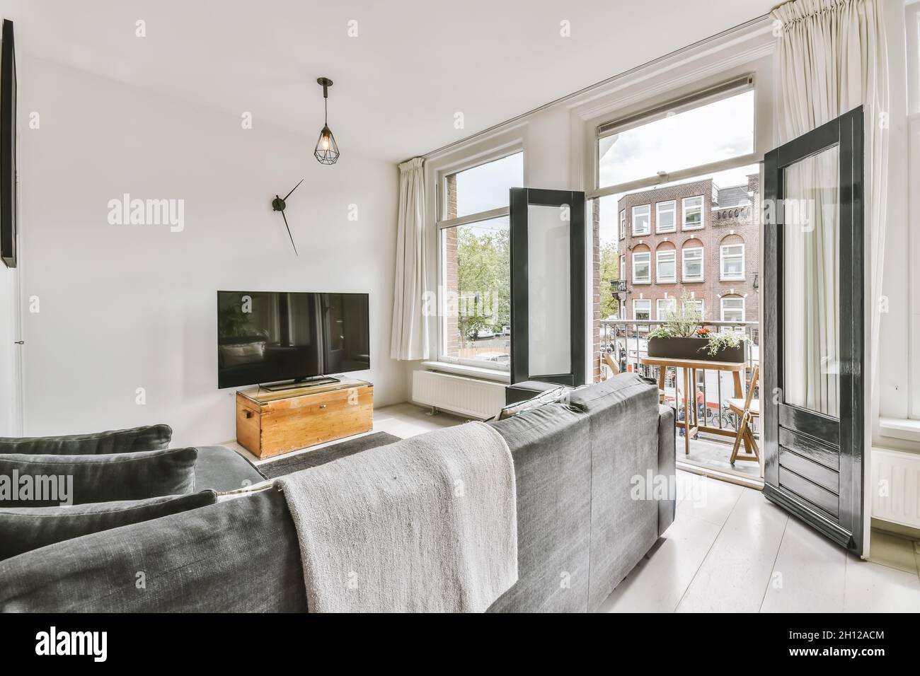 Spacious furnished living room with an exit to an exterior balcony ...
