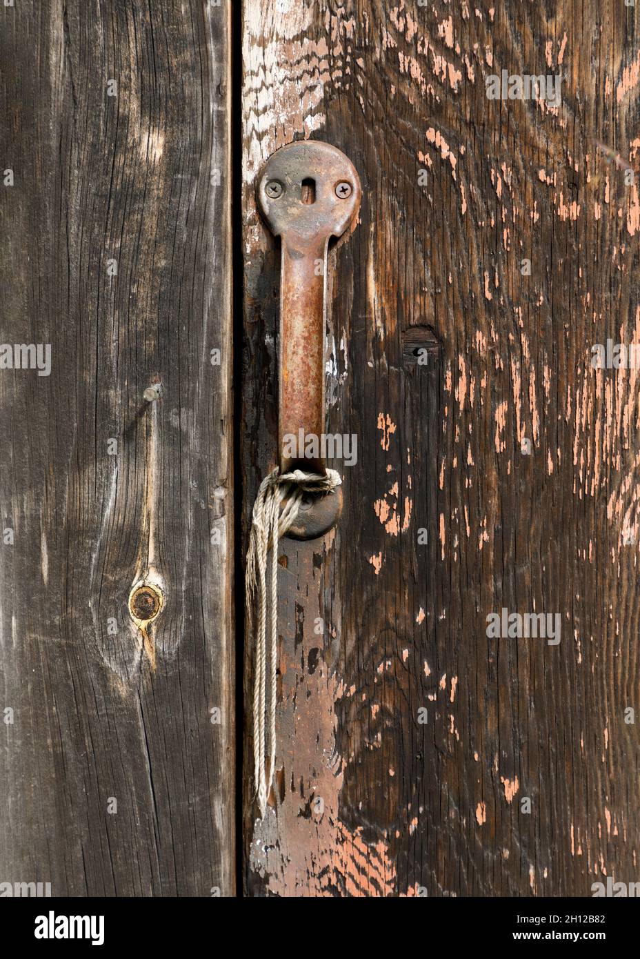 Rusted handle on weathered wood Stock Photo - Alamy