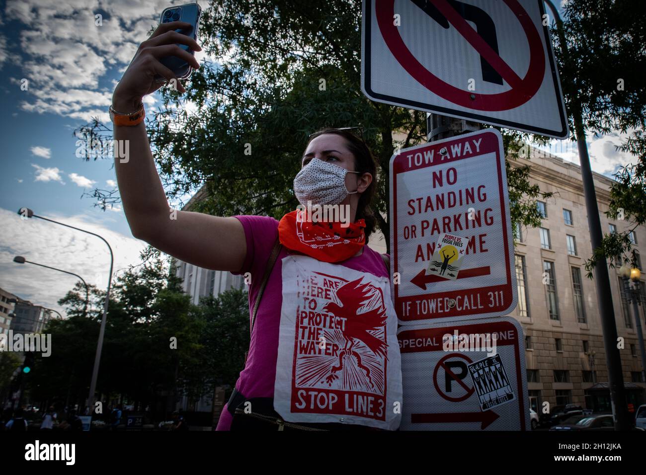 An anti-pipeline protester takes a photo as hundreds of climate ...
