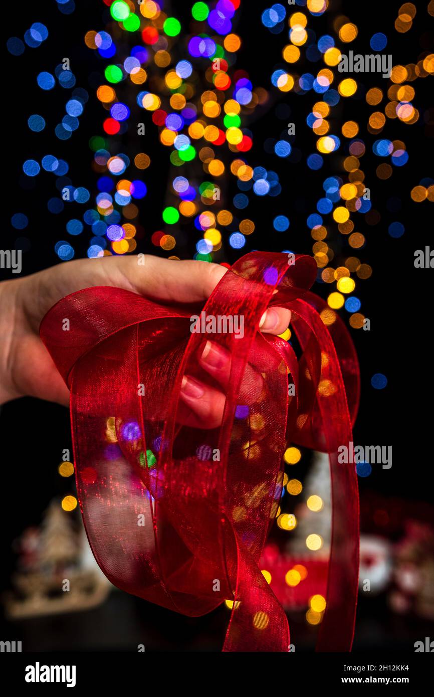 Holding Christmas decoration against bokeh lights background Stock Photo - Alamy