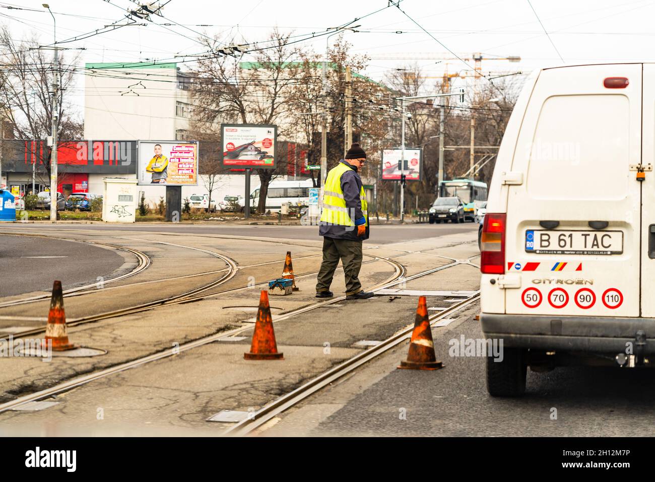 Worker arranging traffic cone on tram railway in Bucharest, Romania ...