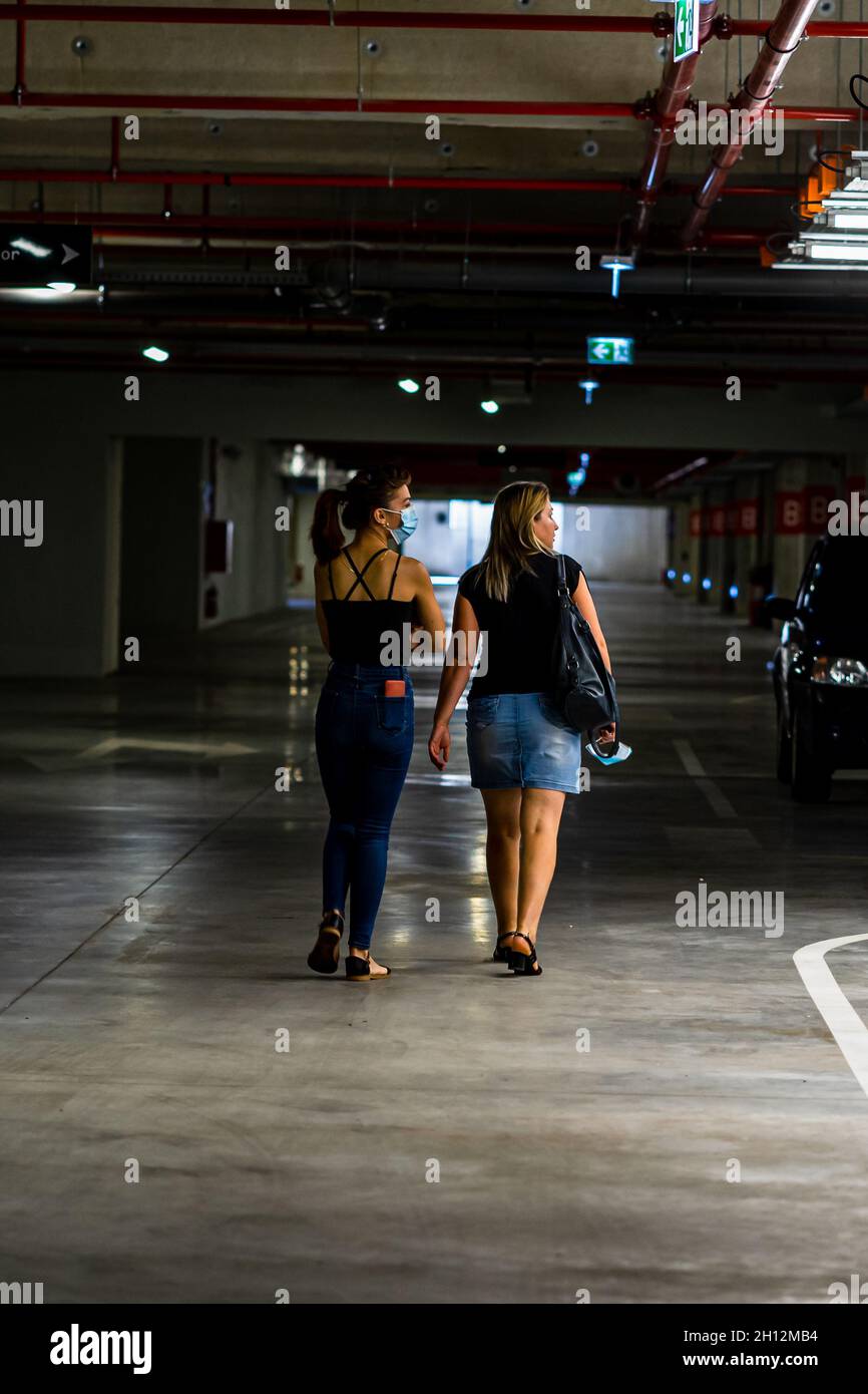 Women walking alone in underground parking garage in Bucharest, Romania ...