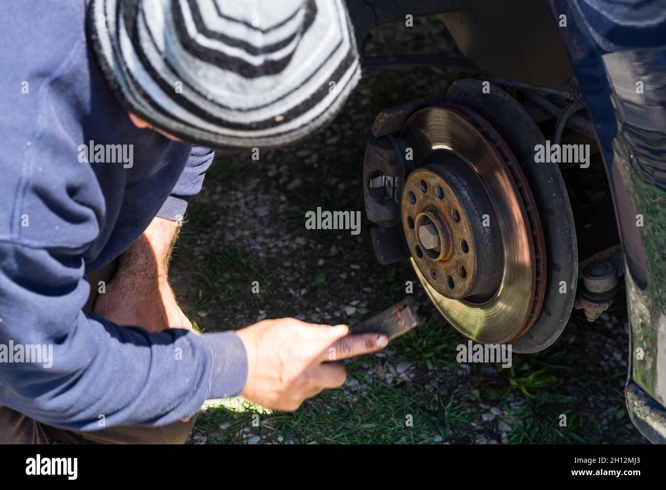 Close up of mechanic changing wheel on car with hand tool in Romania ...