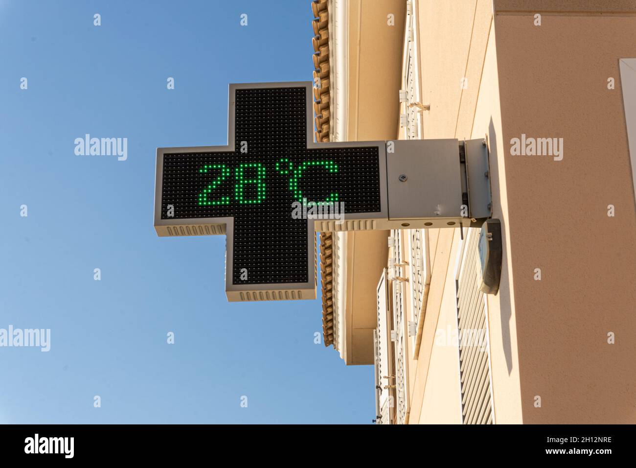 Closeup shot of a pharmacy sign with a 28 Celsius temperature outside ...
