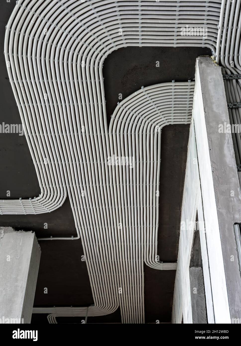 Electrical cables and pipes on house concrete ceiling. Modern plastic ...