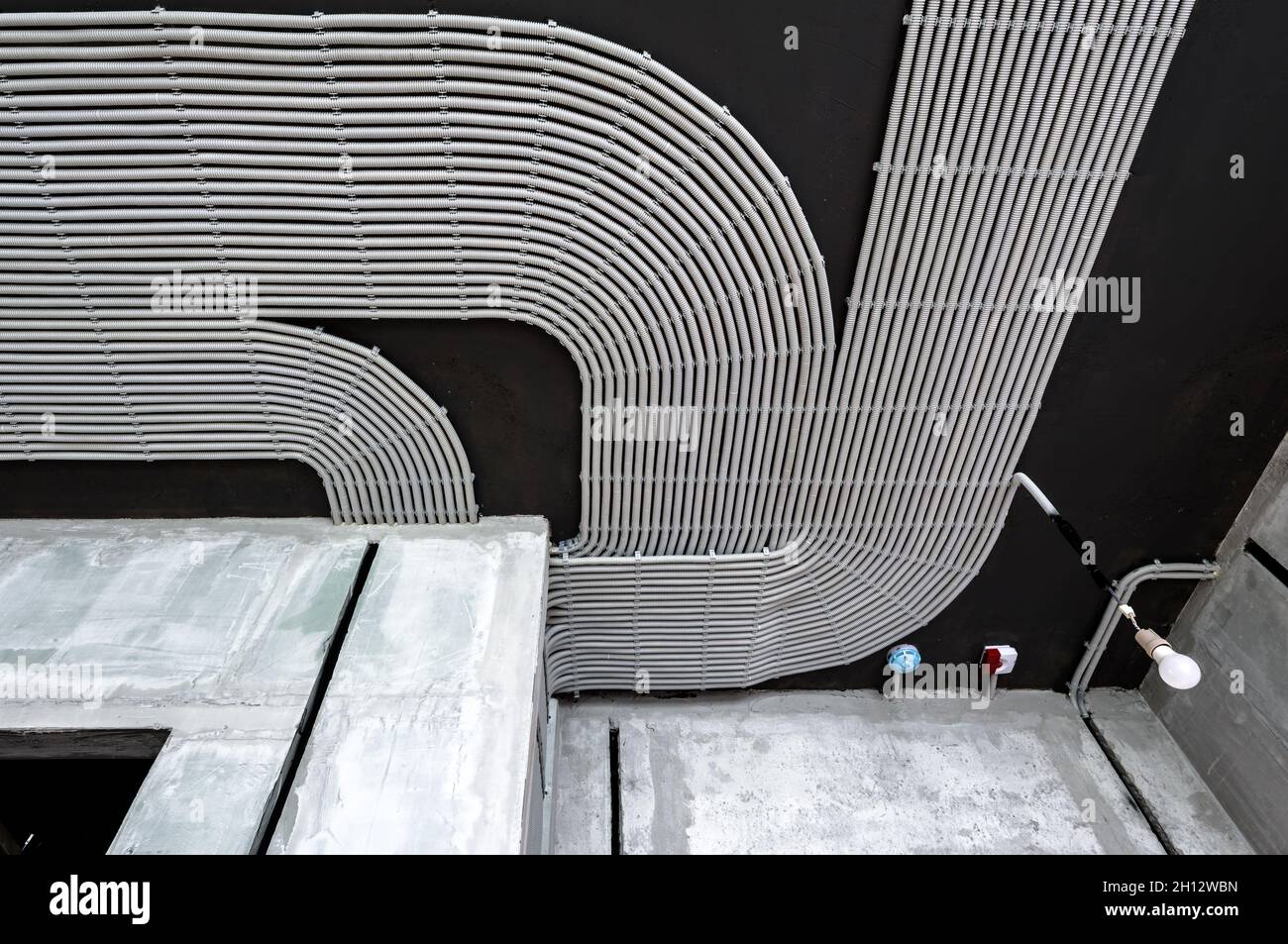 Electrical cables and pipes on house concrete ceiling. Modern plastic ...