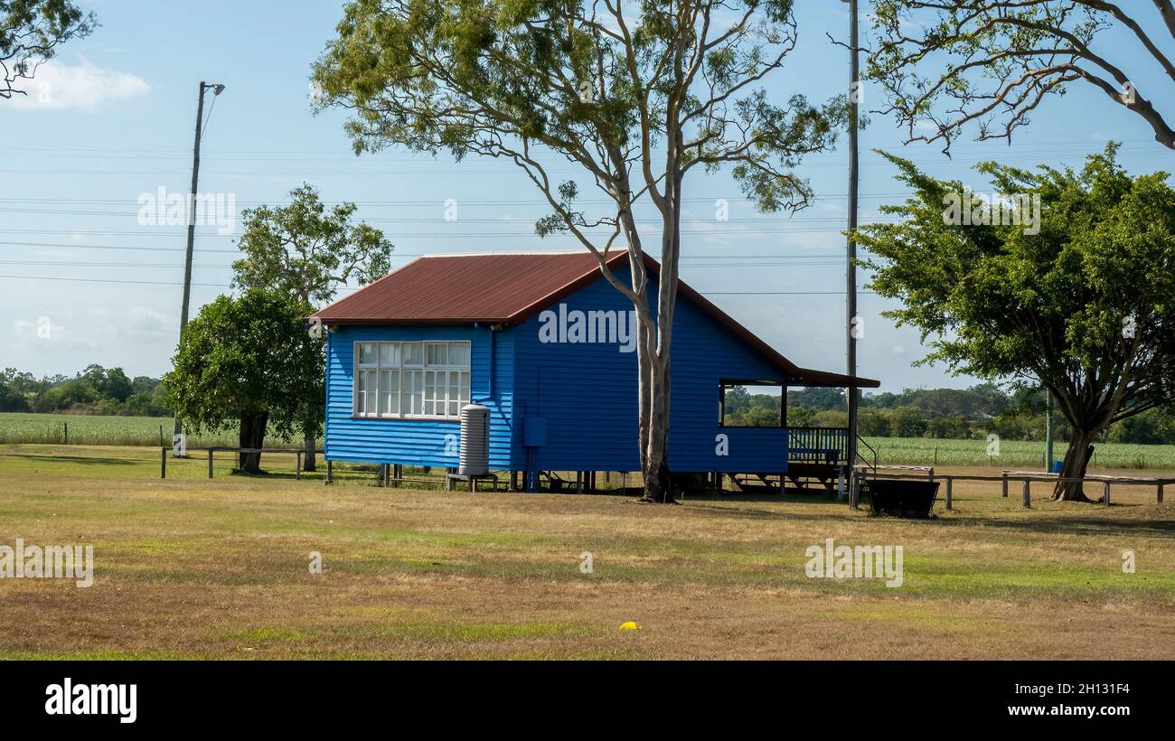 A bright blue painted club house for a rural pony club beside a field ...