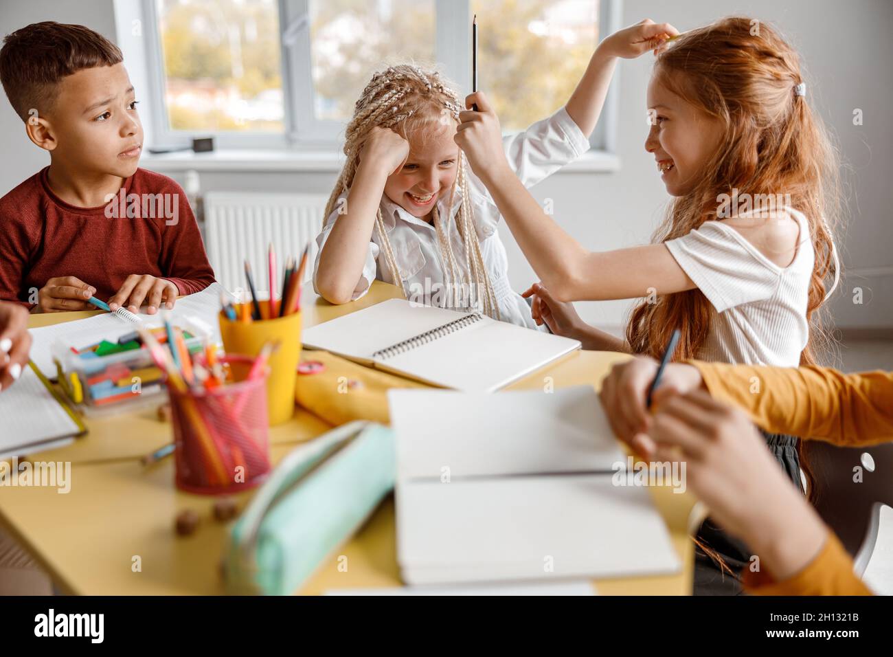 Smiling schoolgirls are having fun in class Stock Photo - Alamy