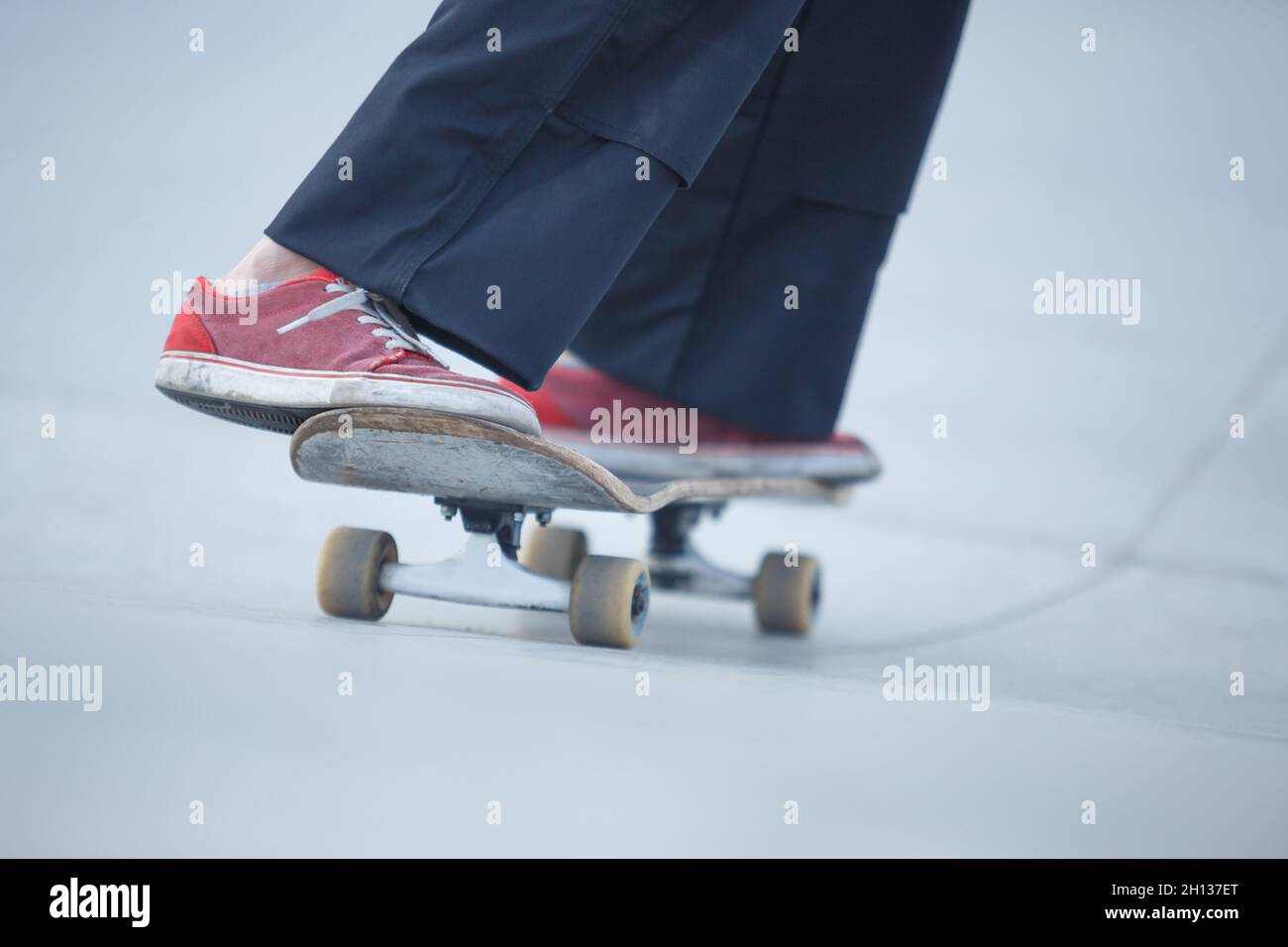 Skater girl rolling on concrete ramp in outdoor skate park. Female ...