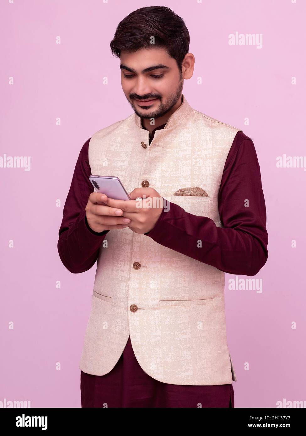 Asian young indian boy wearing traditional dress texting on a ...