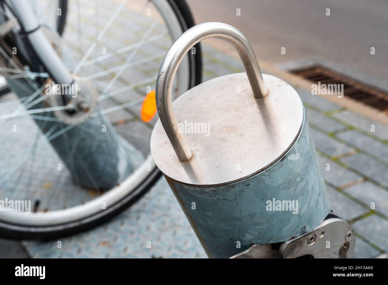 Close - up on a bicycle rack made of metal. Brick pavement and bicycle ...