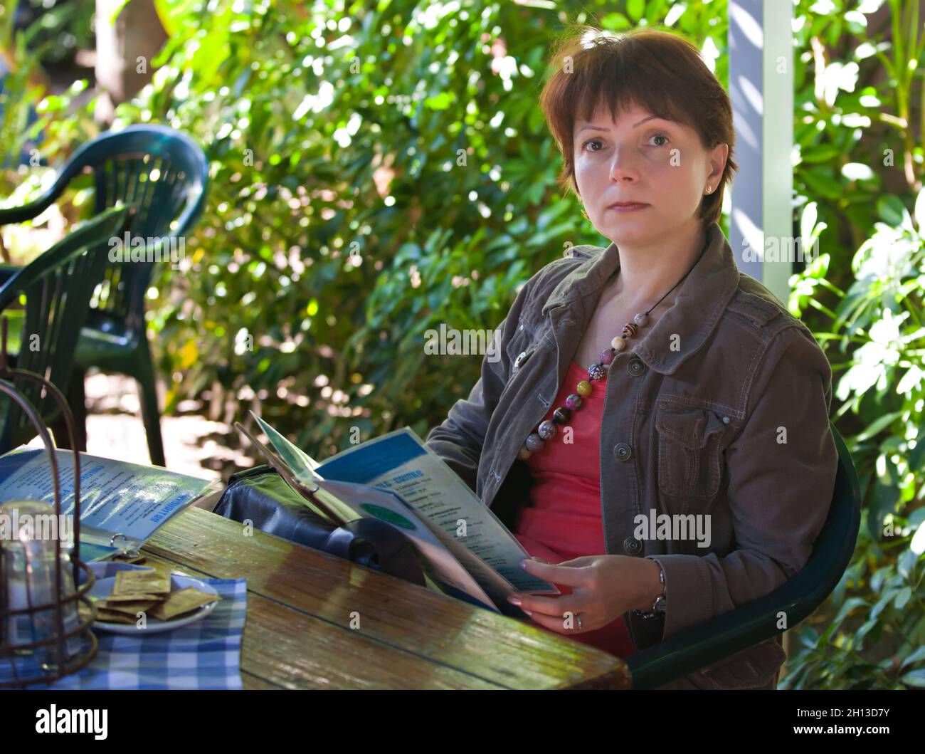 woman reading the menu in her lunch break at a terrace Stock Photo - Alamy