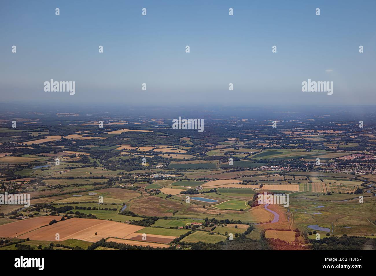 Aerial view of cultivated fields, forests, mountains, and small lakes ...