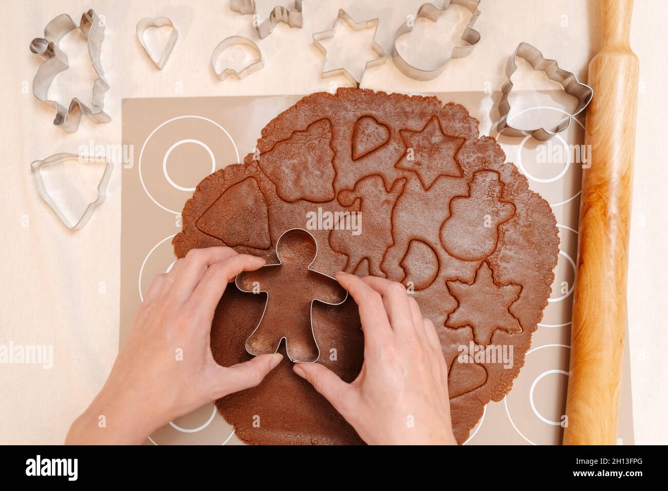 Cooking gingerbread from dough using metal molds top view Stock Photo ...