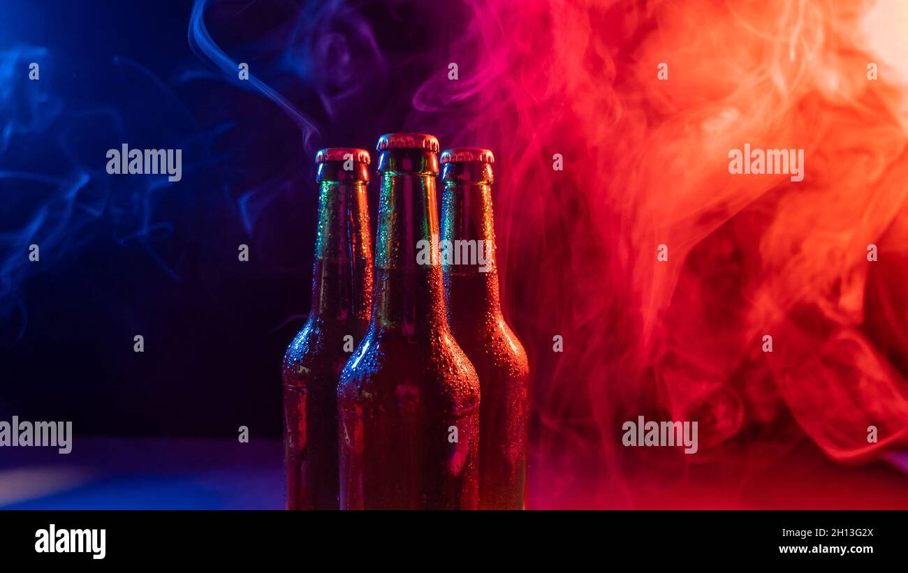 Three bottles of beer in a blue-pink mist Stock Photo - Alamy