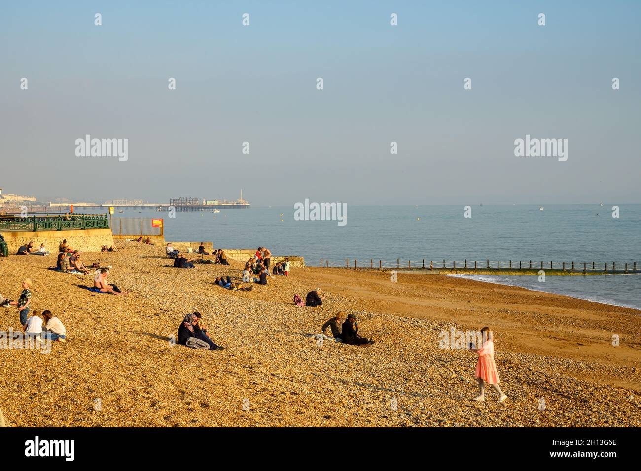 Children and adults sunbathing and playing on Hove beach in glorious ...