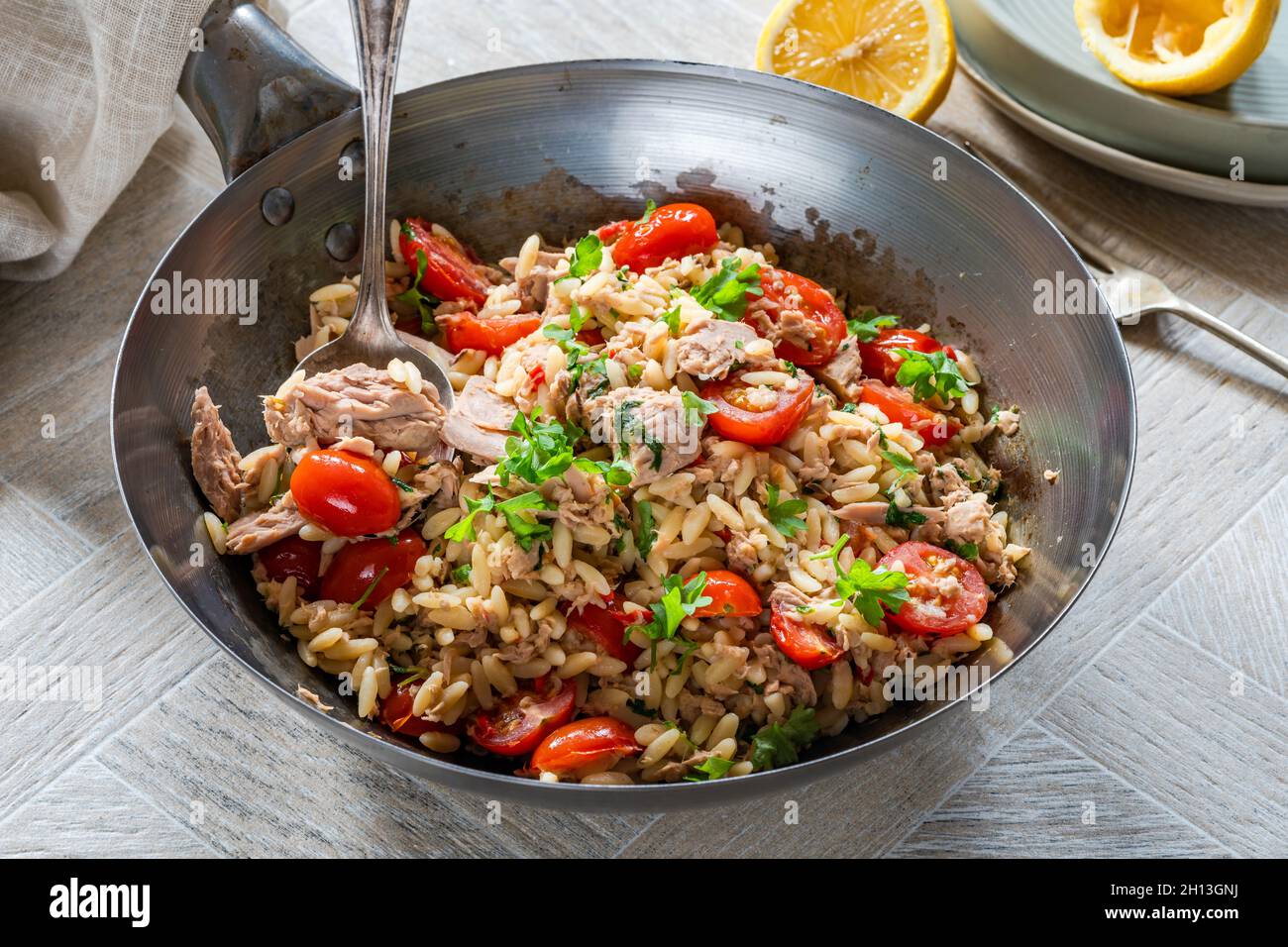 Tuna and orzo pasta with cherry tomatoes and parsley Stock Photo - Alamy