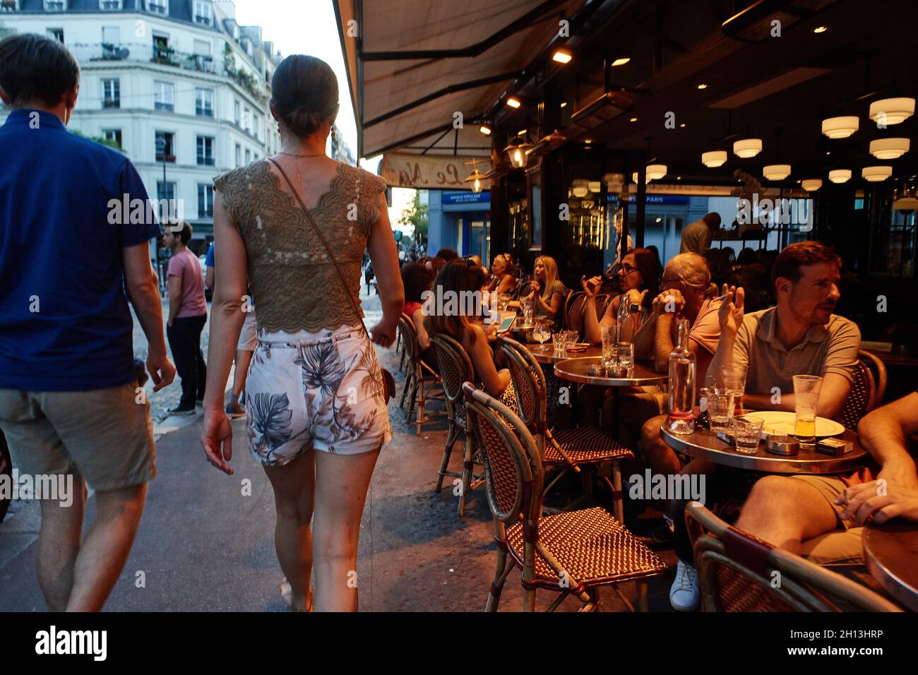 Paris, France - July 2019: French couple walking along bars terrace on ...
