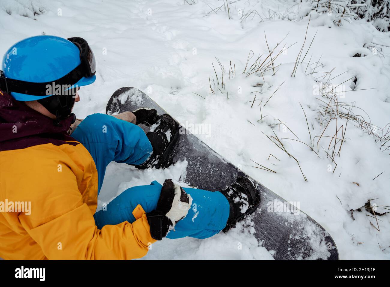 Snowboarder sitting alone in the snow, mountain outdoor, winter sport ...