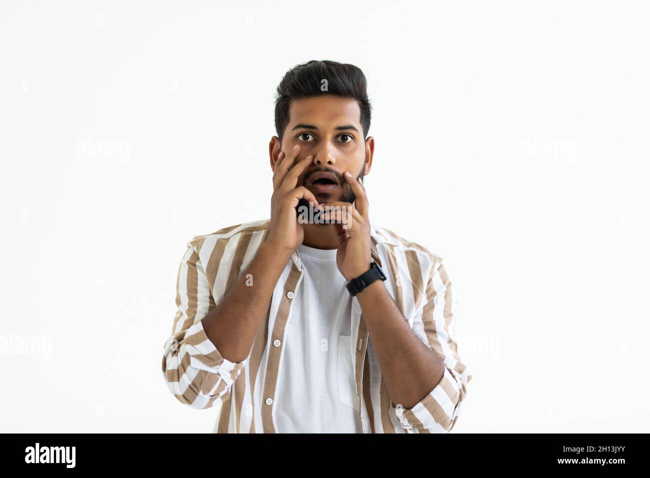 Shocked young Indian man holding hands behind head and keeping mouth ...