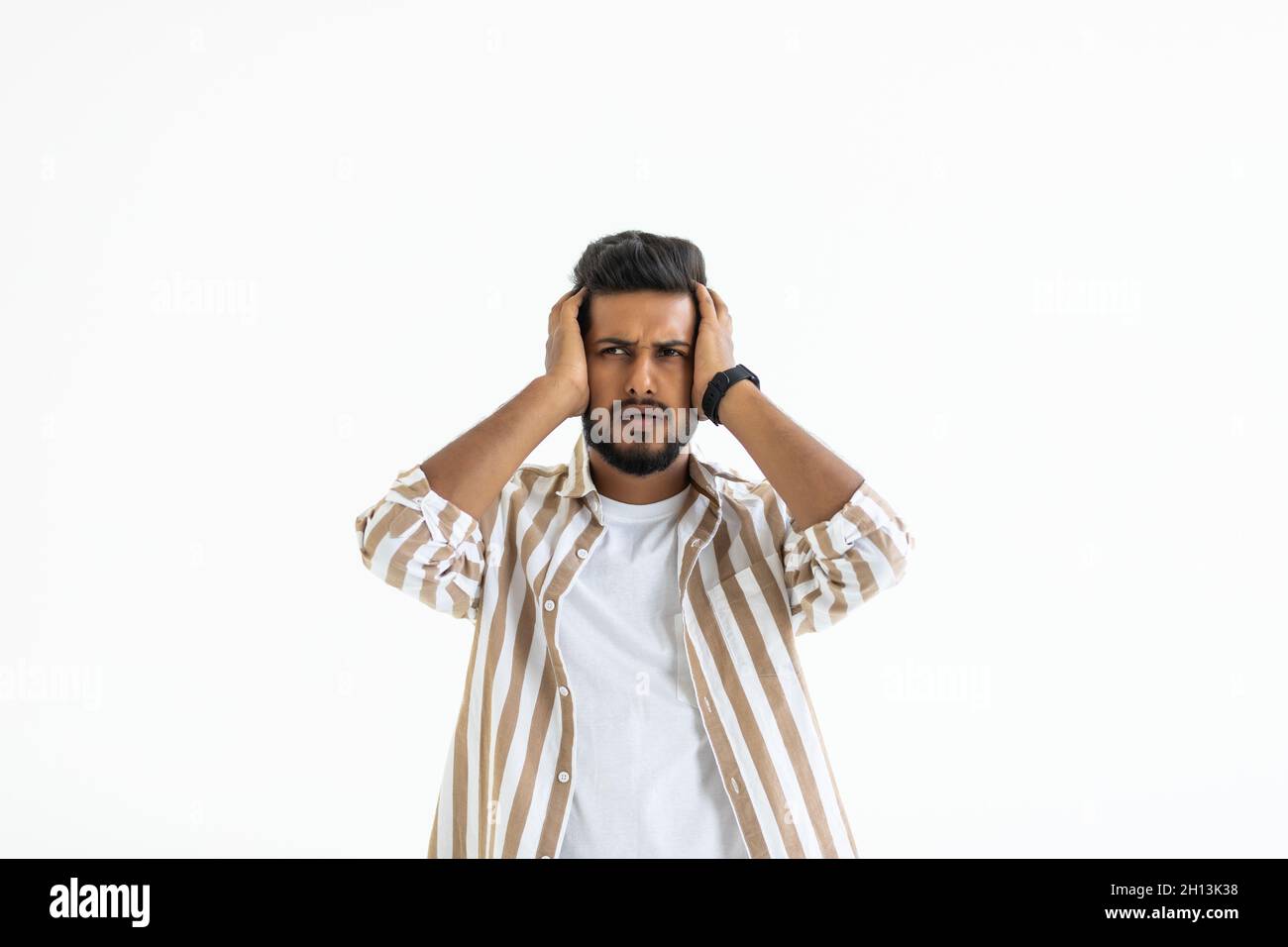 Shocked young Indian man holding hands behind head and keeping mouth ...