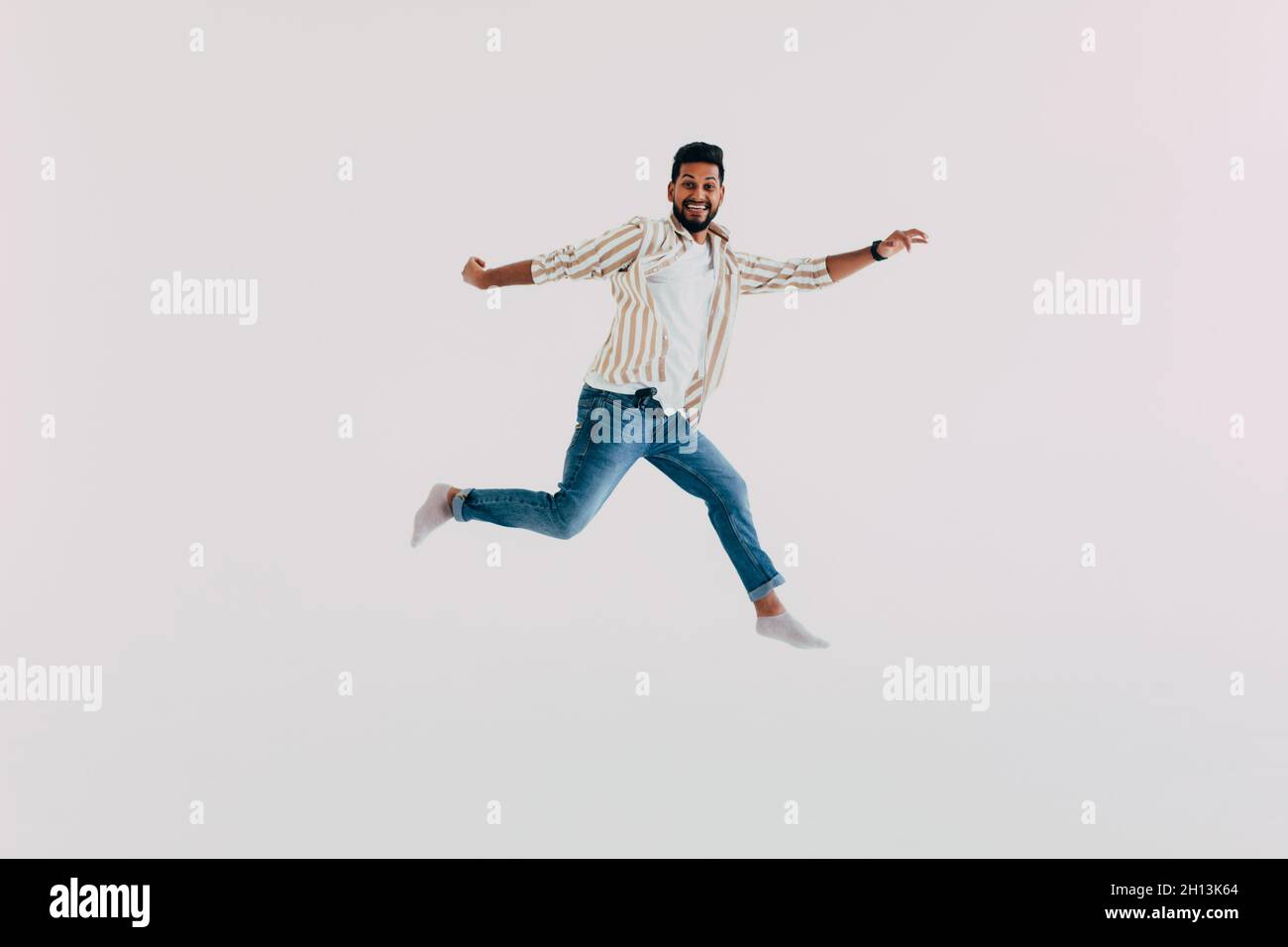 Handsome indian man jumping on white background Stock Photo - Alamy