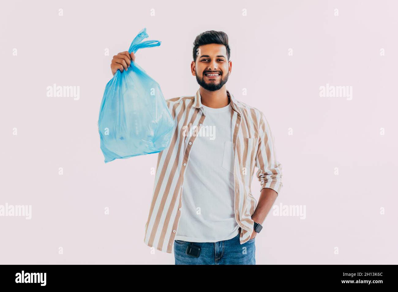 Man holding a plastic bag full of garbage, isolated on white background ...