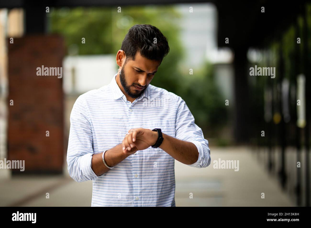 Handsome businessman checking time on his watch Stock Photo - Alamy