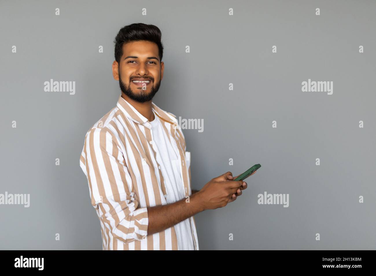 Portrait of indian young man using cellphone on white background Stock ...