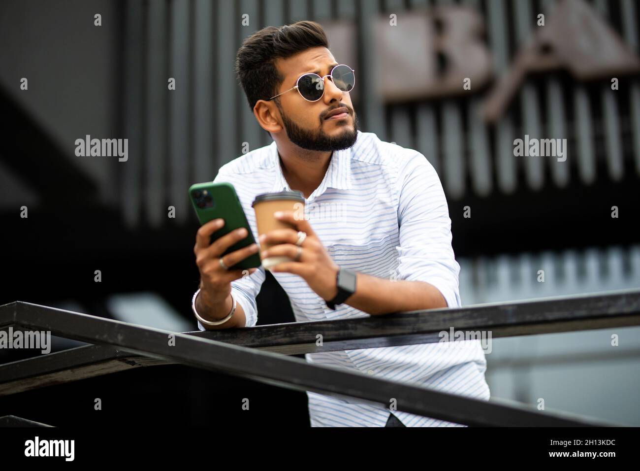 Portrait of indian man use internet networks from phone on the street ...