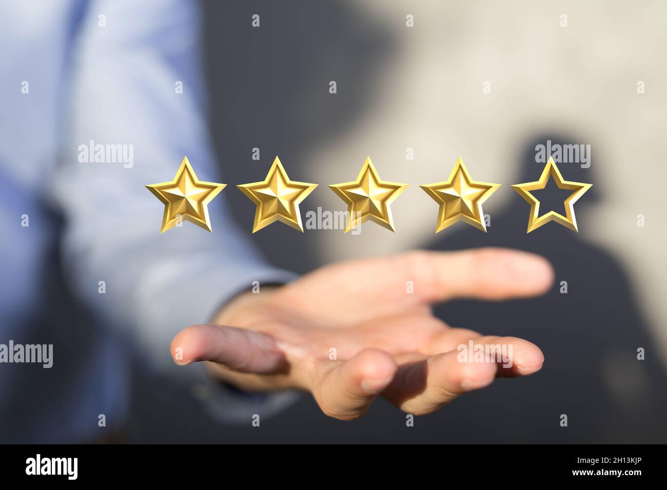 Abstract shot of a man showing 3D rendered golden rating stars with a 4 ...