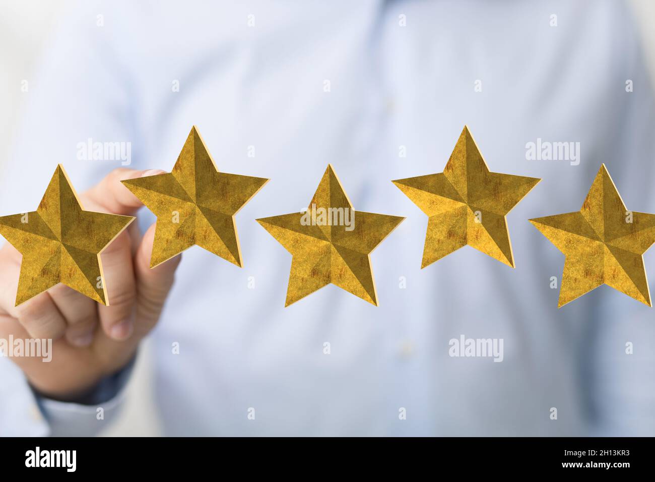 Abstract shot of man touching 3D rendered golden rating stars with a 5 ...