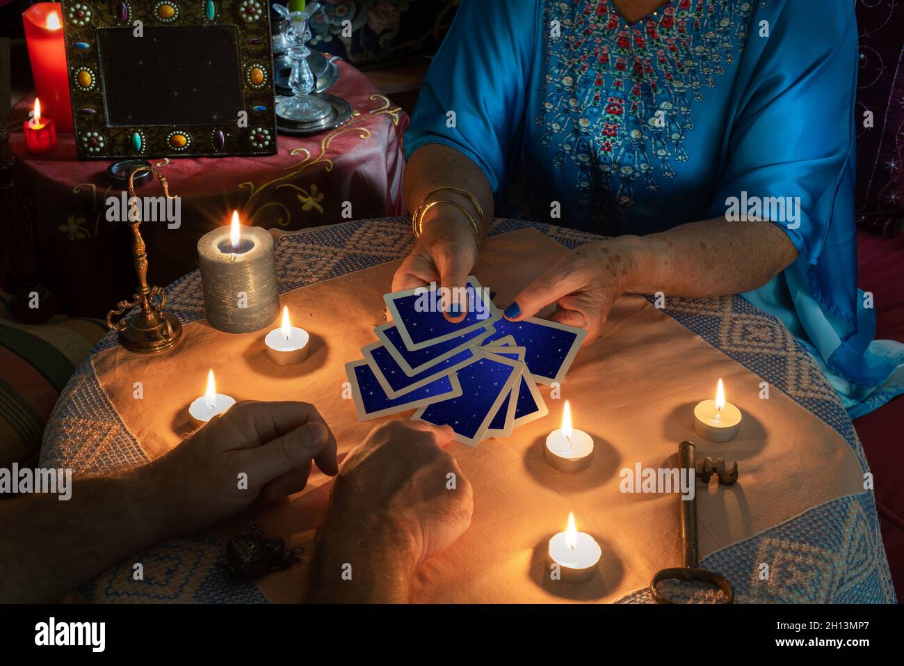 The Pythoness chooses a Tarot card in an esoteric session with candles ...