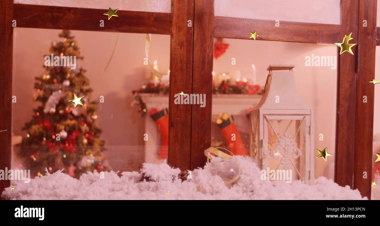 Image of glowing stars falling over christmas tree seen through window ...
