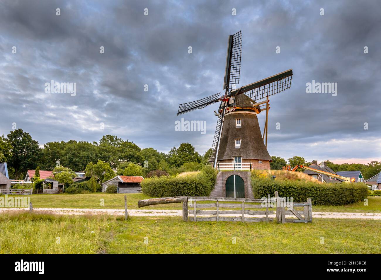Historic wooden windmill under clouded sky in village of Aalden ...