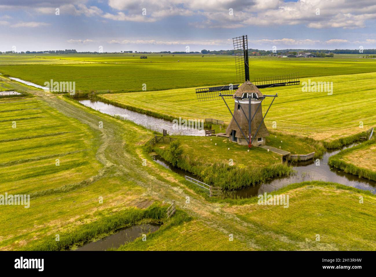 Old wooden windmill in green agricultural grassland. Friesland, the ...