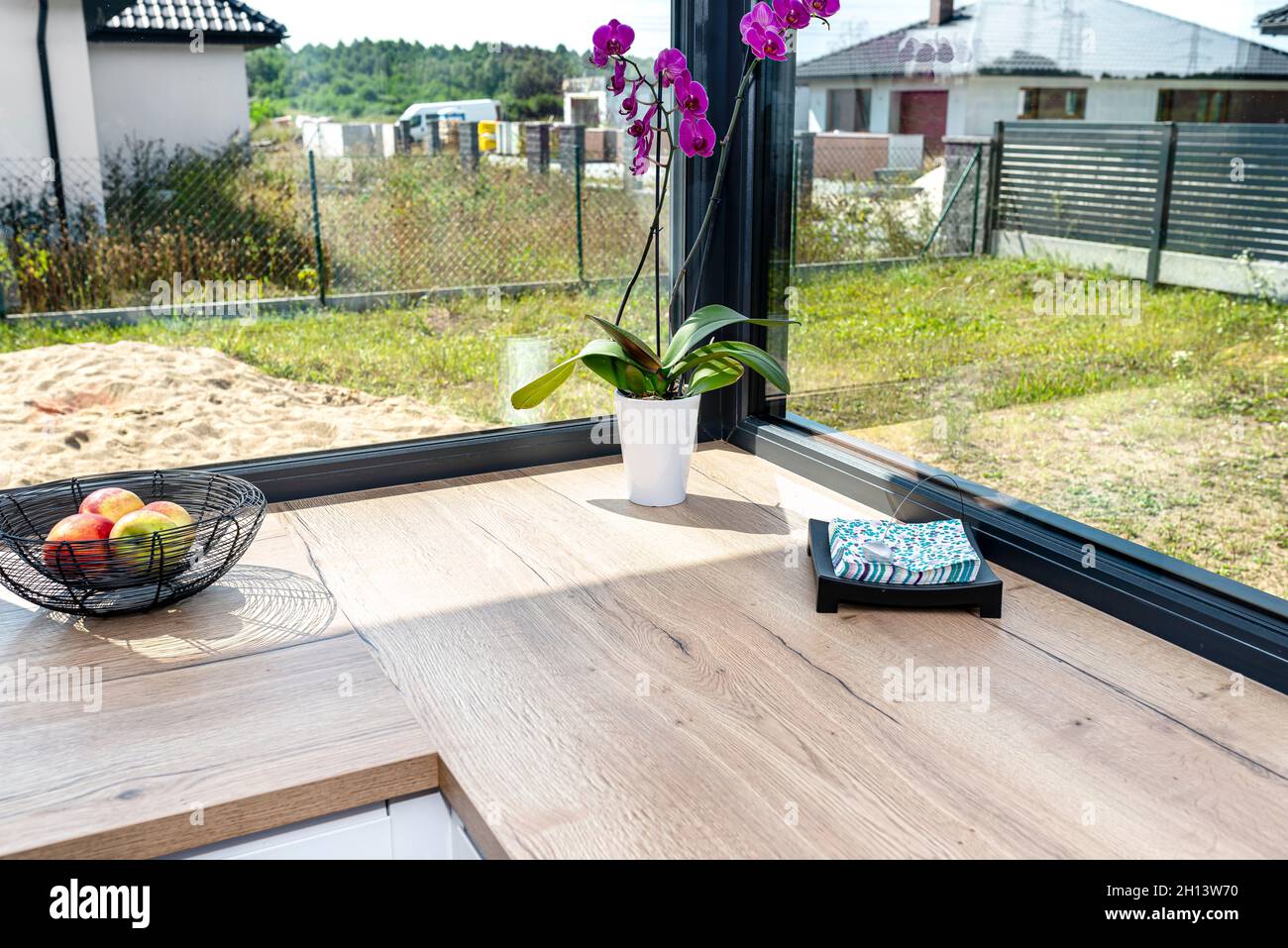Large corner window in a modern kitchen with built-in cabinets against ...
